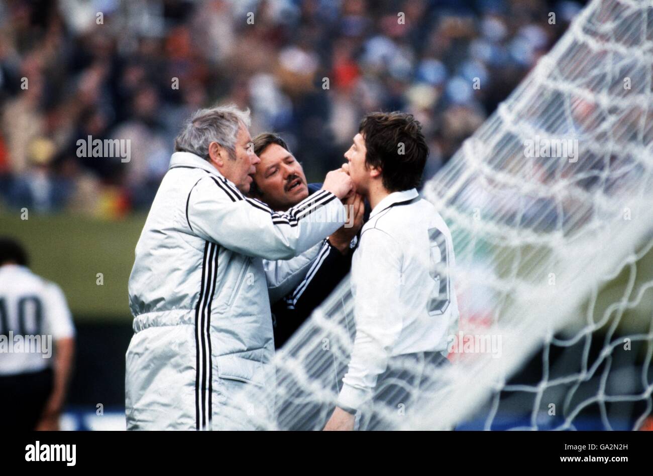 (L-R) The West Germany trainers have a look at the injured Klaus ...