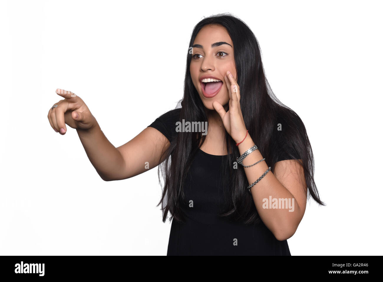 Young beautiful woman surprised pointing something. Isolated white ...