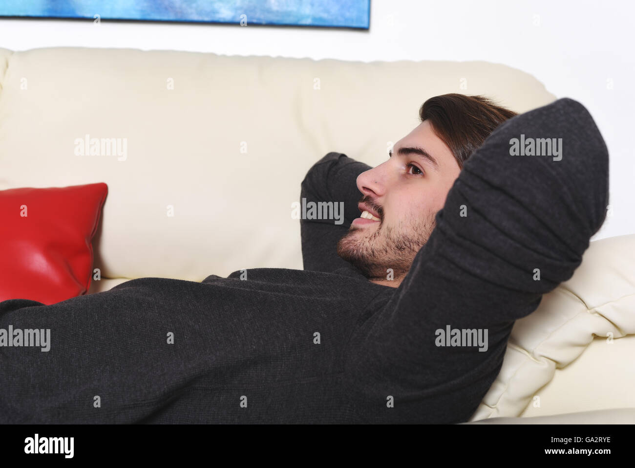 Close up to happy young man lying on couch and relaxing. Indoor Stock ...