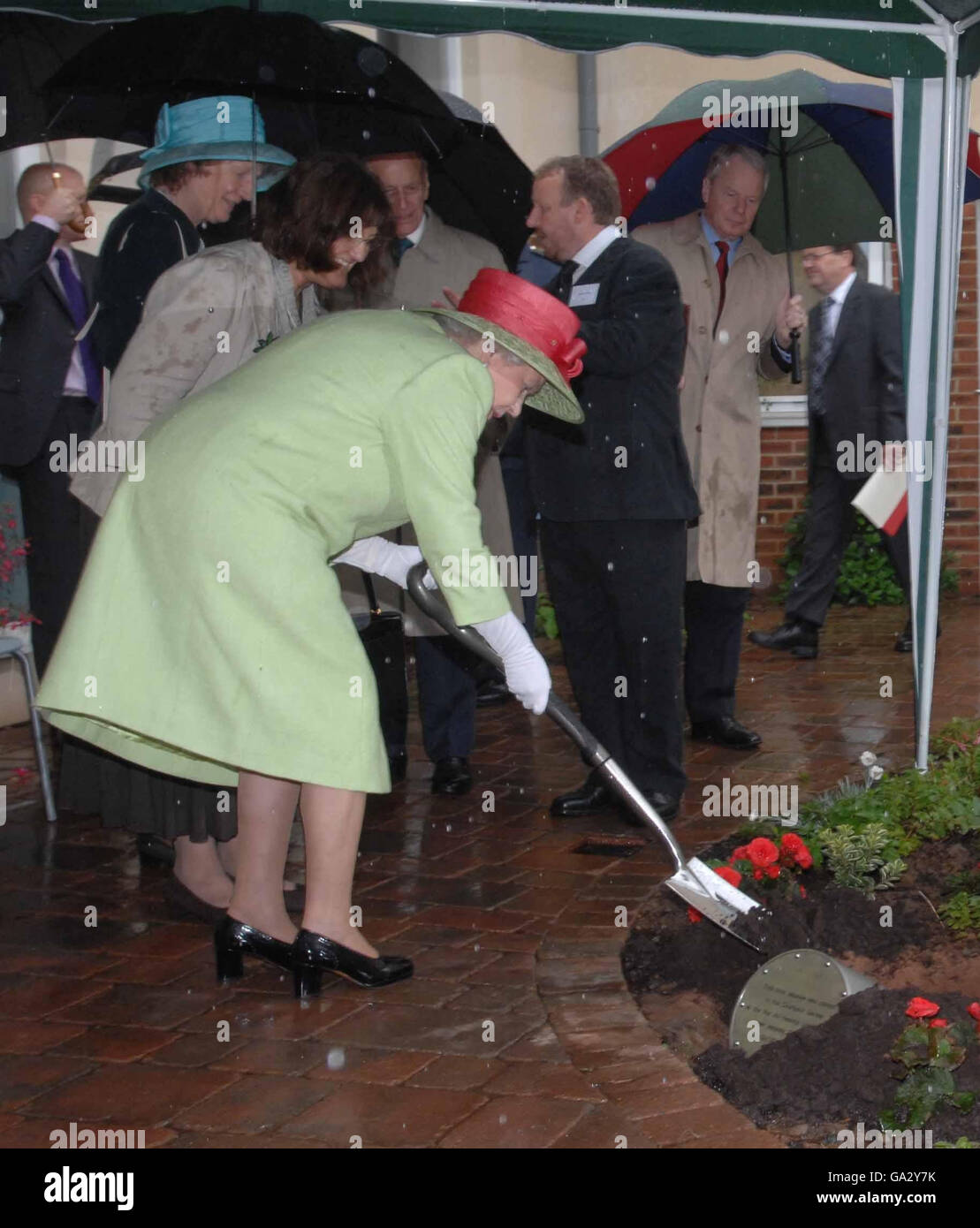 Queen Elizabeth II buries a time capsule during her visit to the All ...