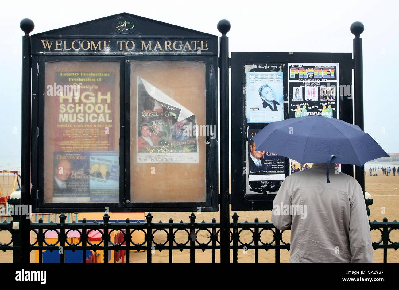 A tourist reads a notice board on the seafront in Margate, Kent as bad ...