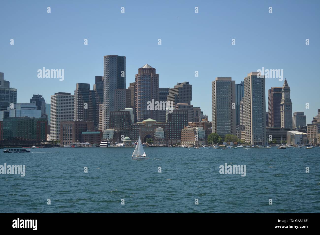 The Boston Skyline seen from the Boston harbor with sail boats and ...