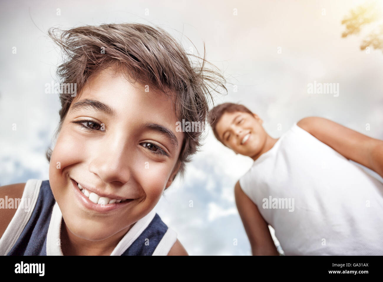 Portrait of a happy boys smiling to camera and having fun, over grey ...