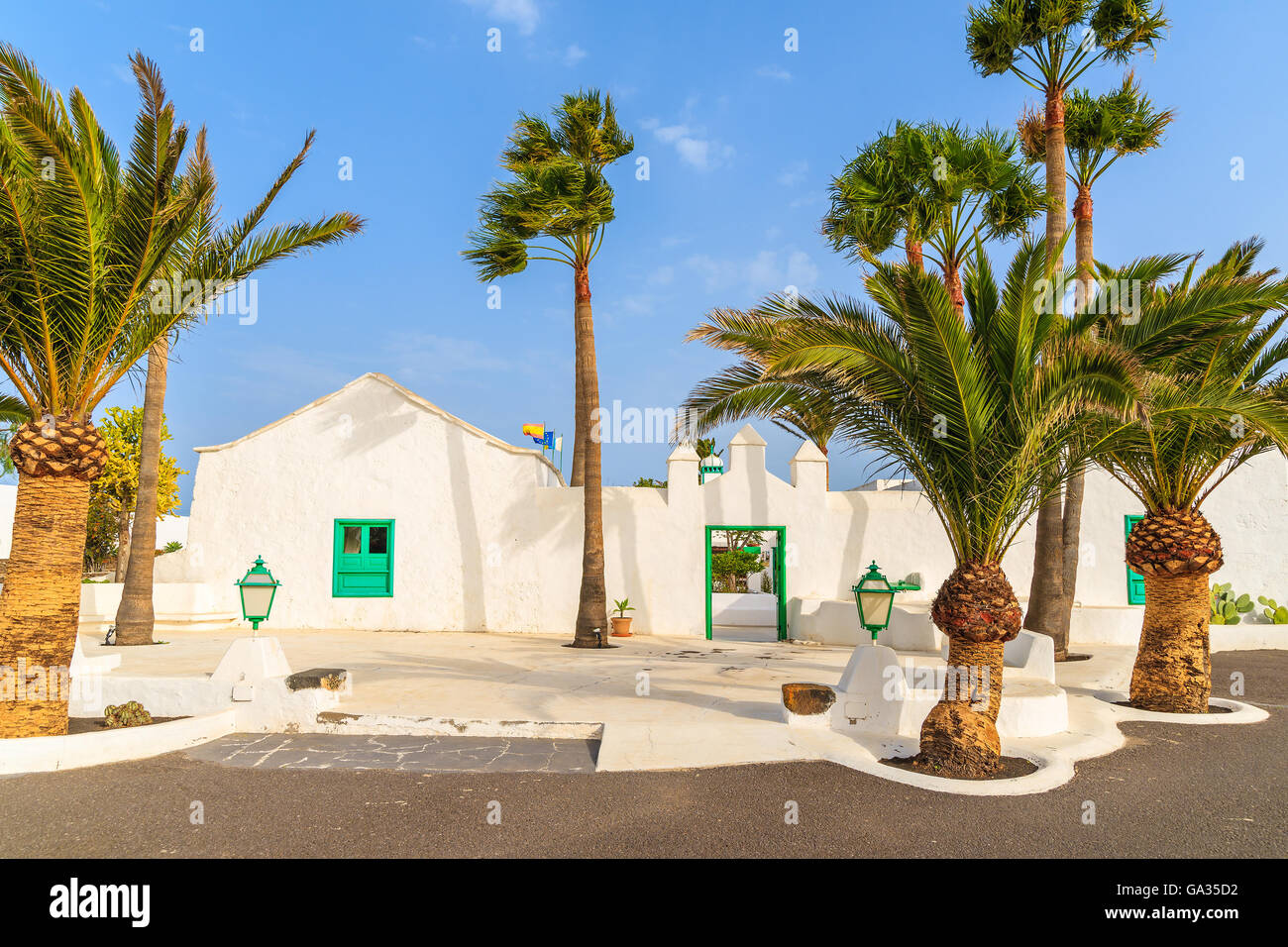 Traditional white houses and palm trees in Yaiza village, Lanzarote ...