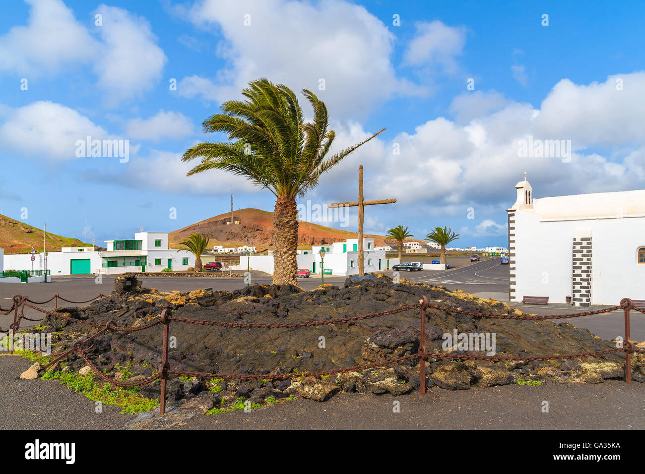 Palm tree and typical white church in Tinajo village near Timanfaya ...