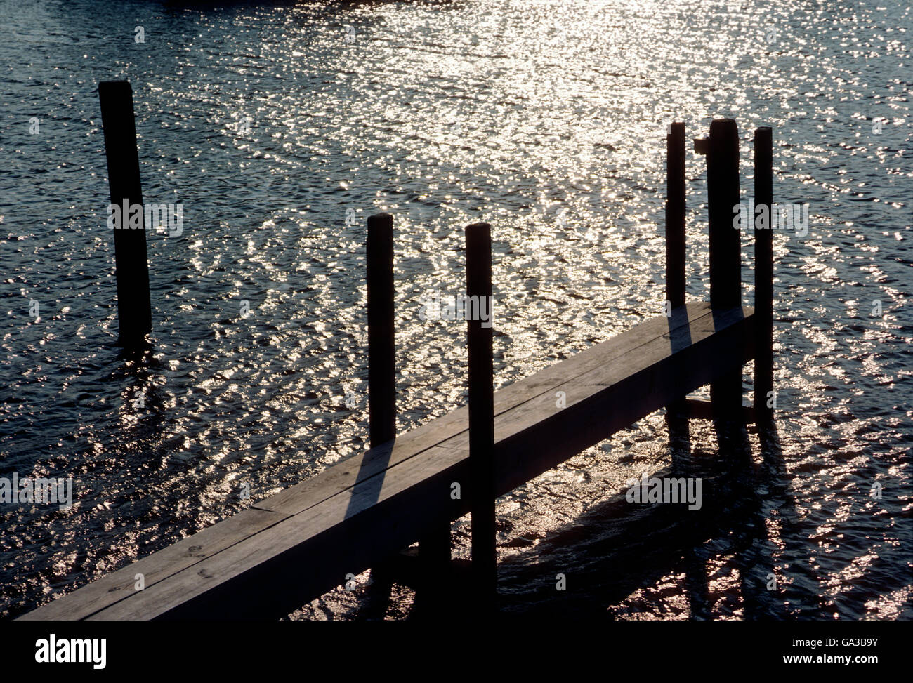 Sun reflecting off ripples in lake; dock; New Jersey; USA Stock Photo ...