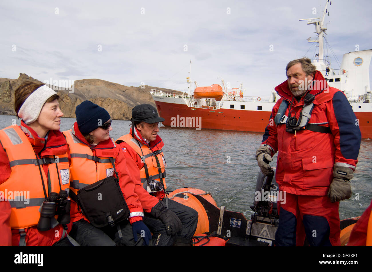 Tourists wearing lifejackets on a boat, Telephone Bay, Deception Island ...