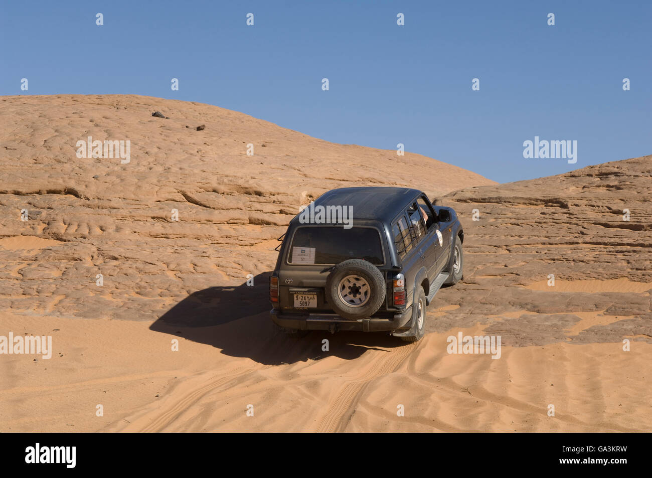 SUV climbing rock, Akakus, Acacus Mountains or Tadrart Acacus, Sahara ...