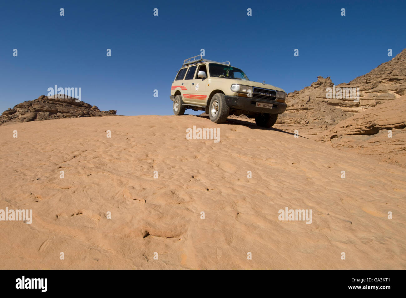 SUV climbing rock, Akakus, Acacus Mountains or Tadrart Acacus, Sahara ...
