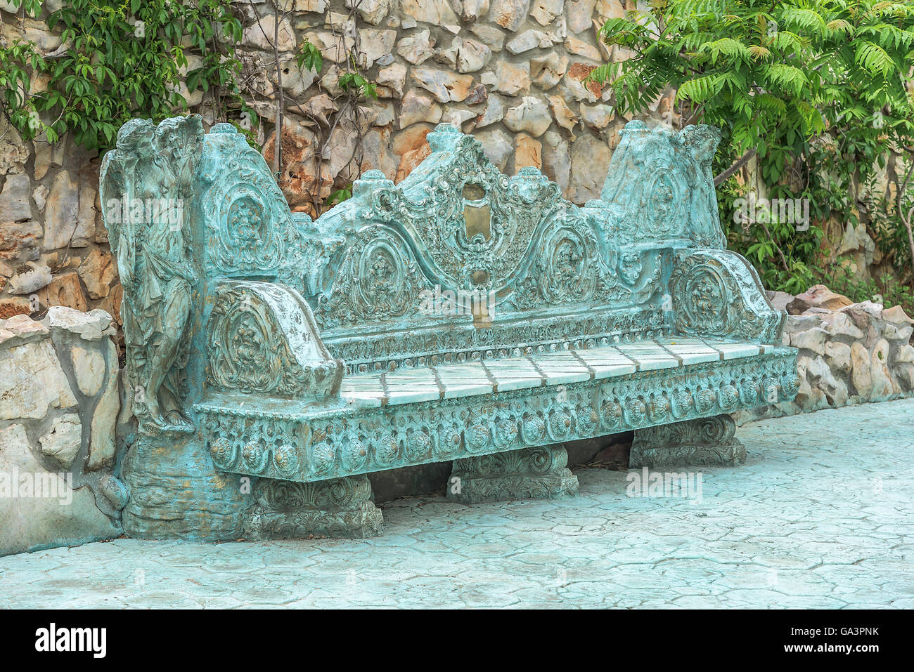 Ancient stone bench with ornament and decorative trees around Stock ...