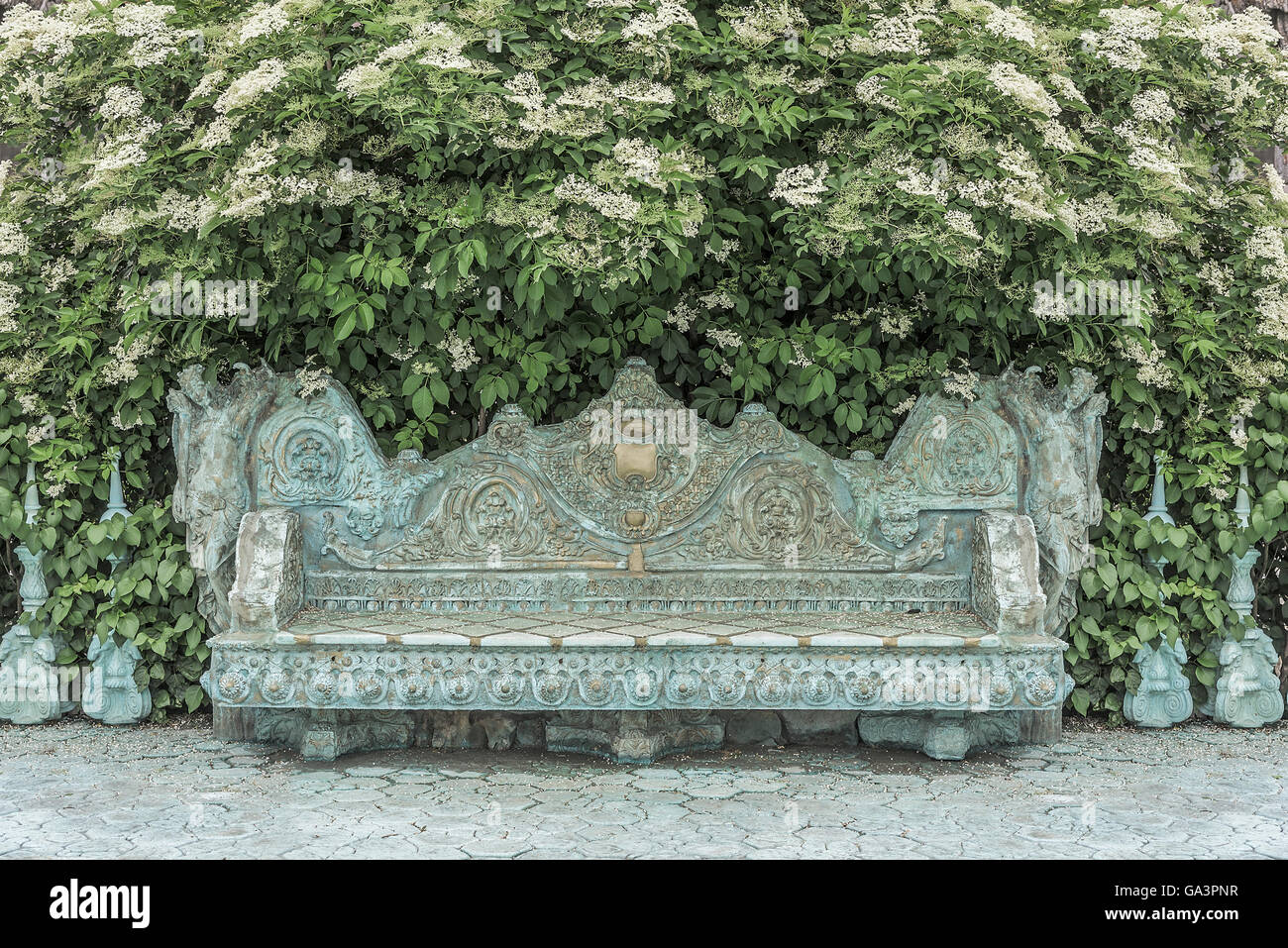 Ancient stone bench with ornament and decorative trees around Stock ...