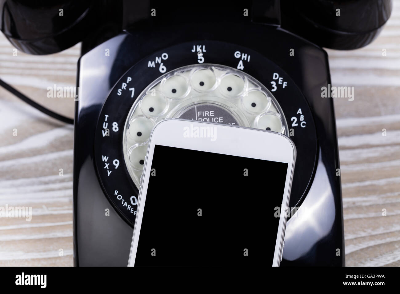 Close up of a partial cellphone with old rotary phone in background ...