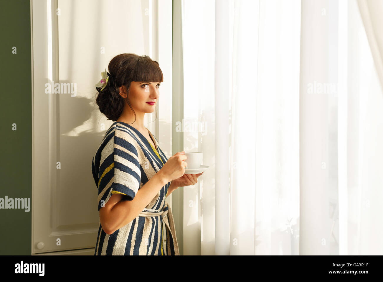 Pretty girl drinking morning coffee by the window. Good morning Stock ...