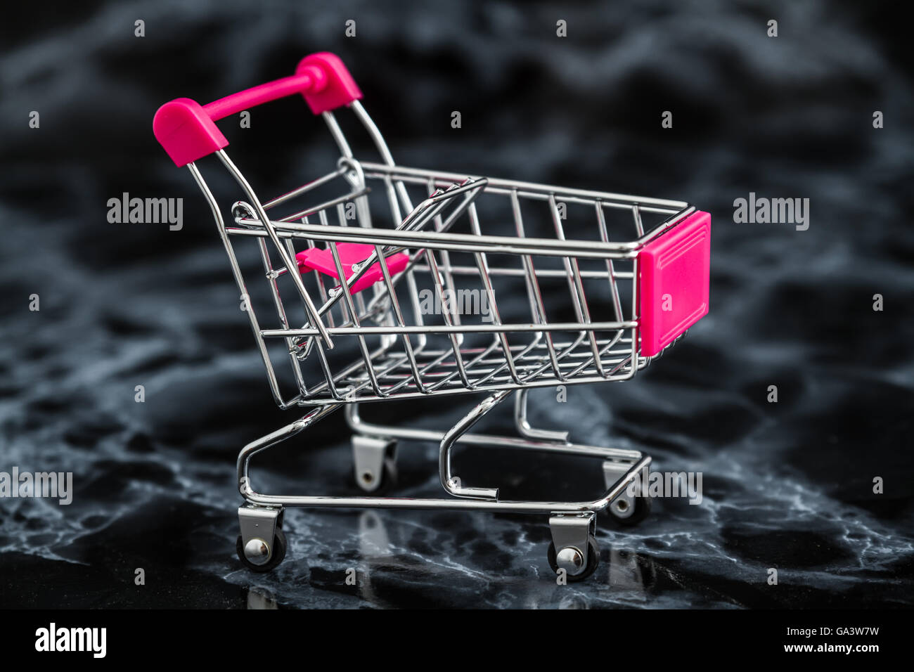 Miniature shopping chart on black marble background Stock Photo - Alamy