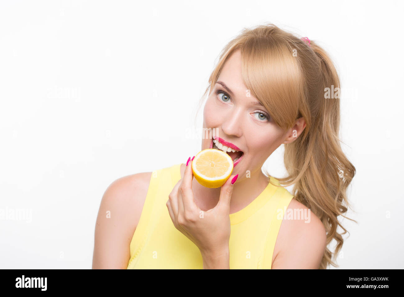 girl biting a lemon Stock Photo - Alamy