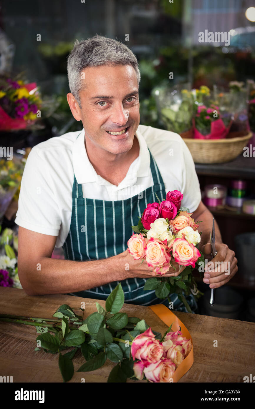 Male florist holding bunch of flowers at flower shop Stock Photo - Alamy