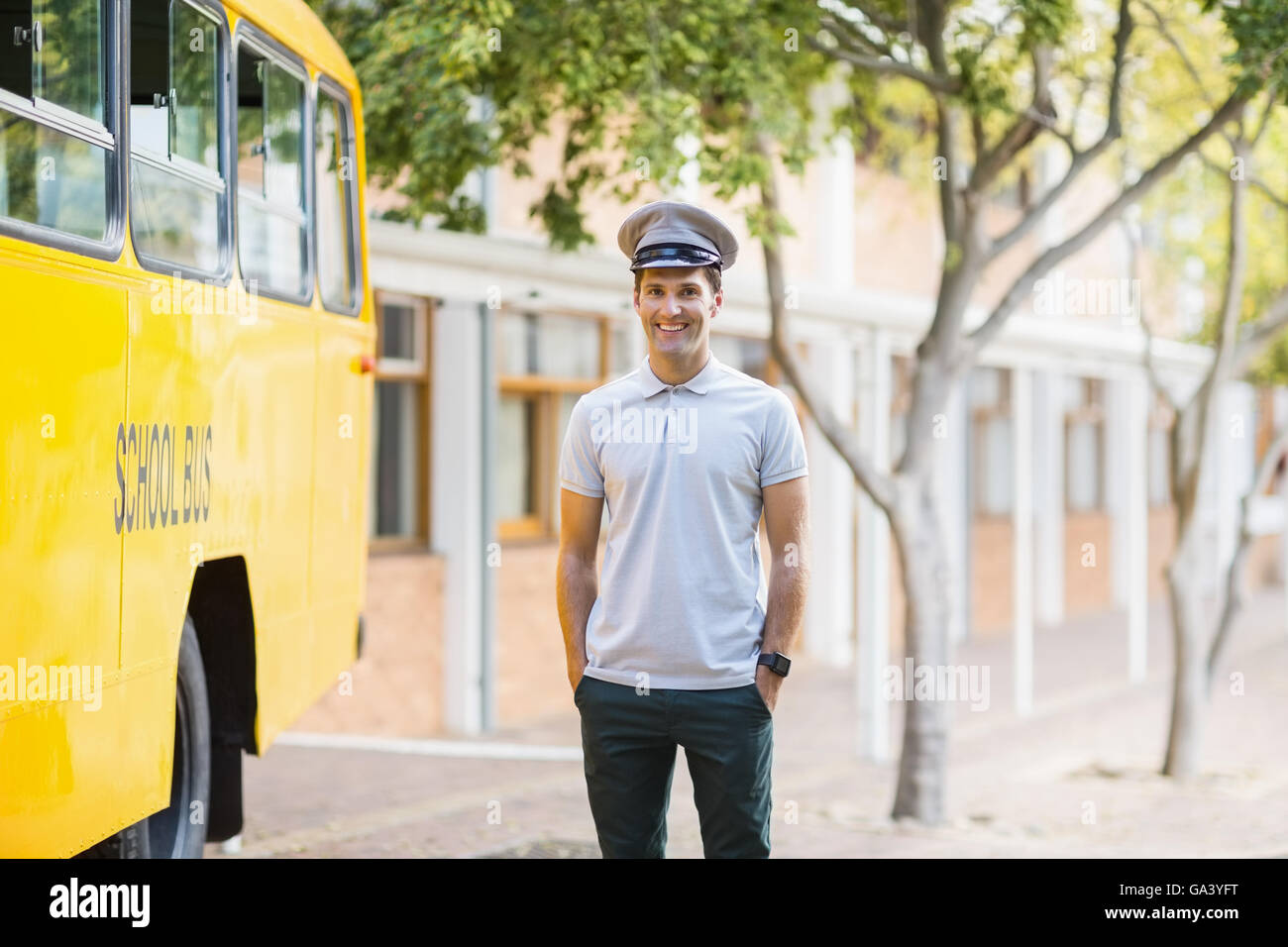 Smiling bus driver standing with hands in pocket in front of bus Stock ...
