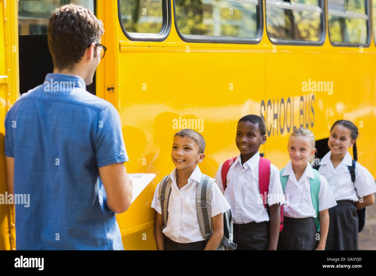 Teacher updating check list of kids Stock Photo - Alamy
