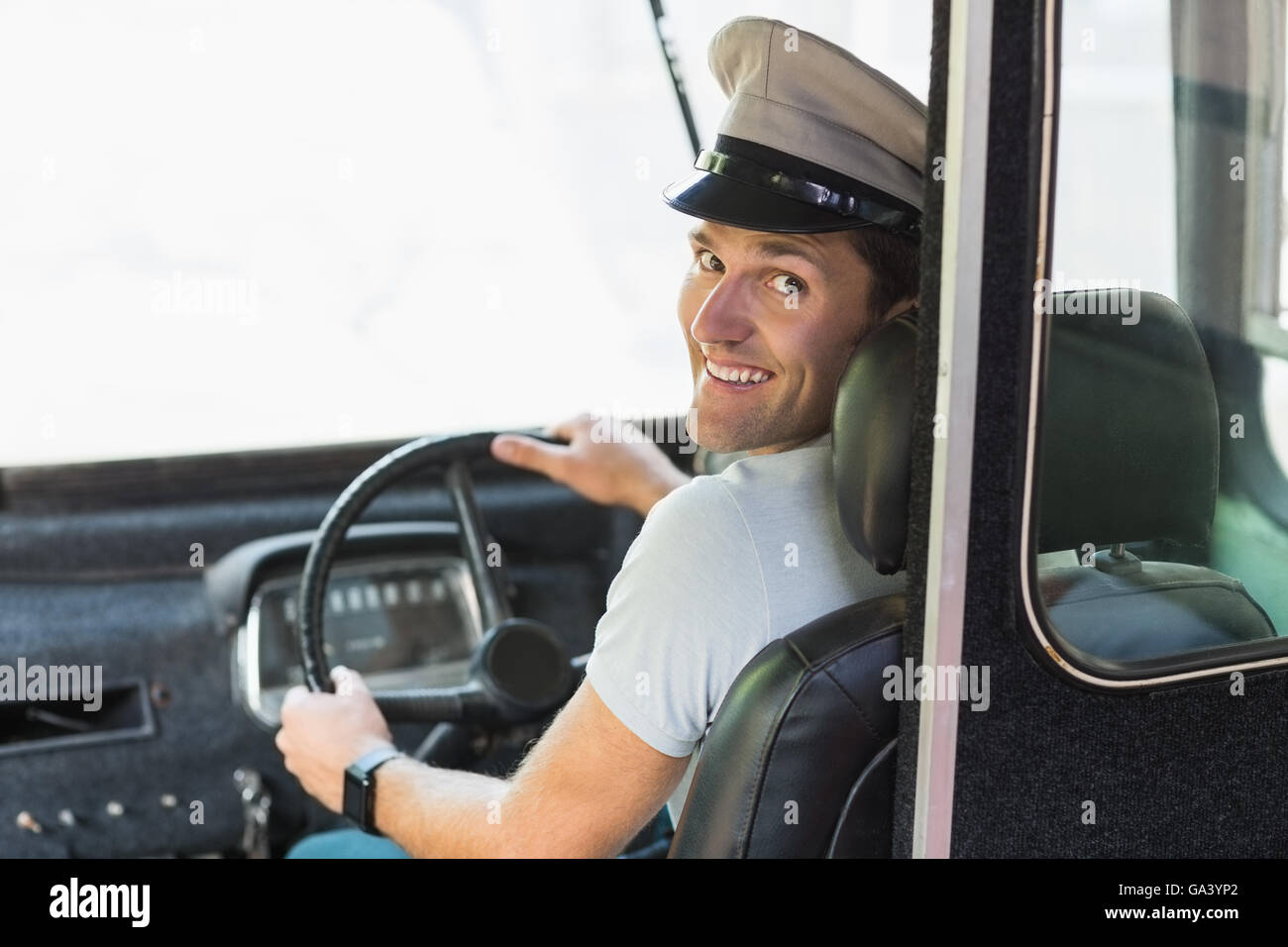 Smiling bus driver driving a bus Stock Photo - Alamy