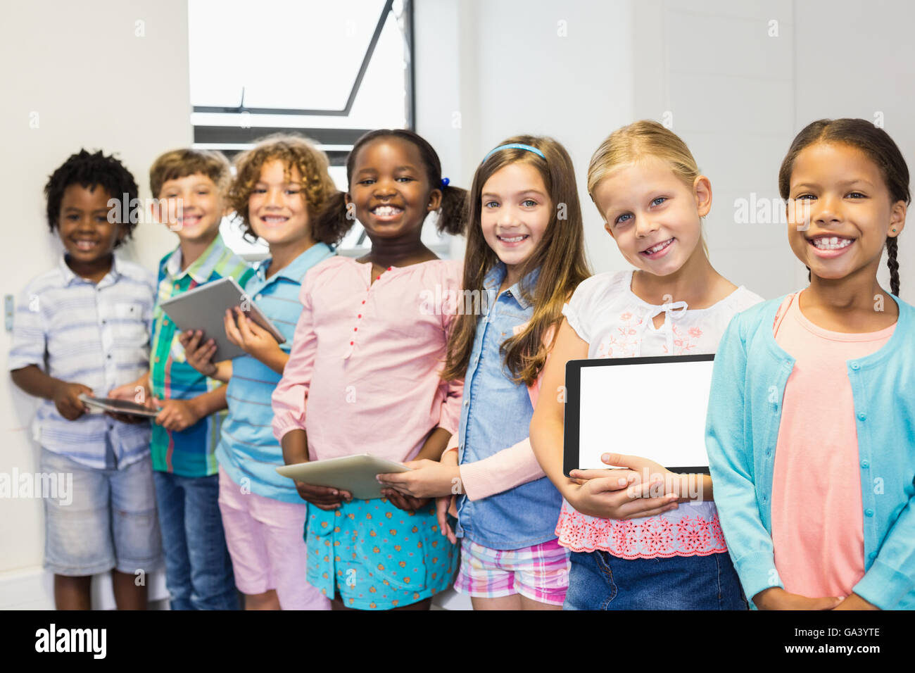 Portrait of students holding digital tablet in classroom Stock Photo ...