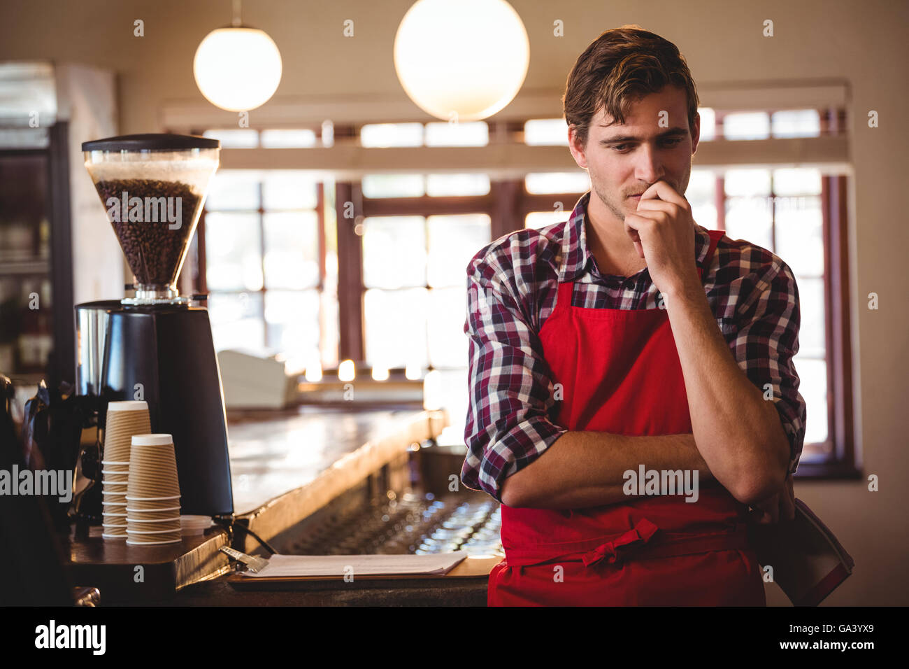 Thoughtful waiter standing at counter Stock Photo - Alamy