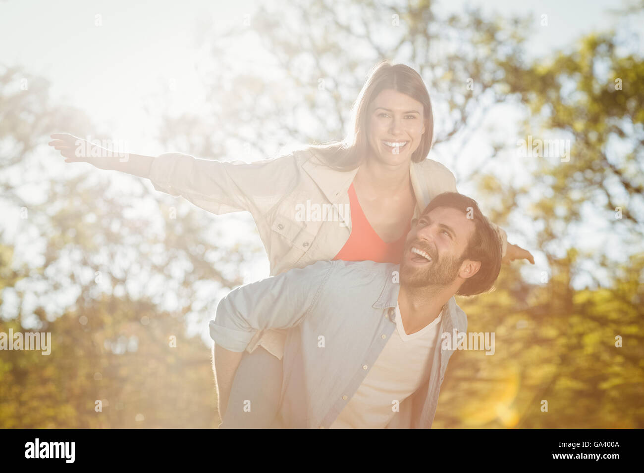 Man giving woman piggyback ride Stock Photo - Alamy