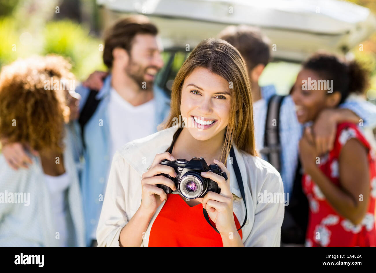 Beautiful woman clicking a photo from camera in park Stock Photo - Alamy
