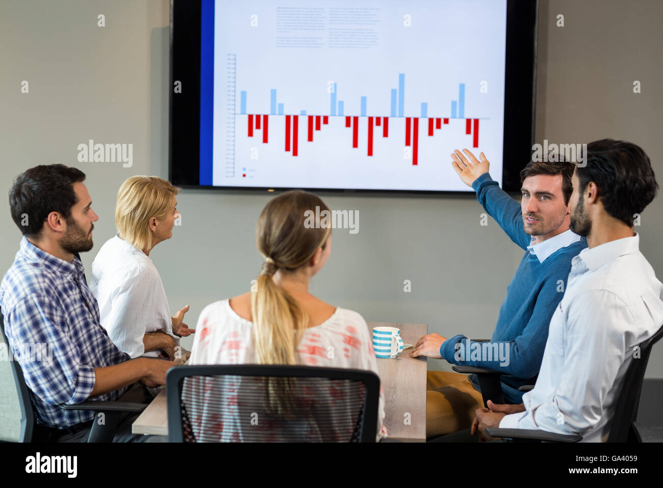 Business people discussing over graph during a meeting Stock Photo - Alamy