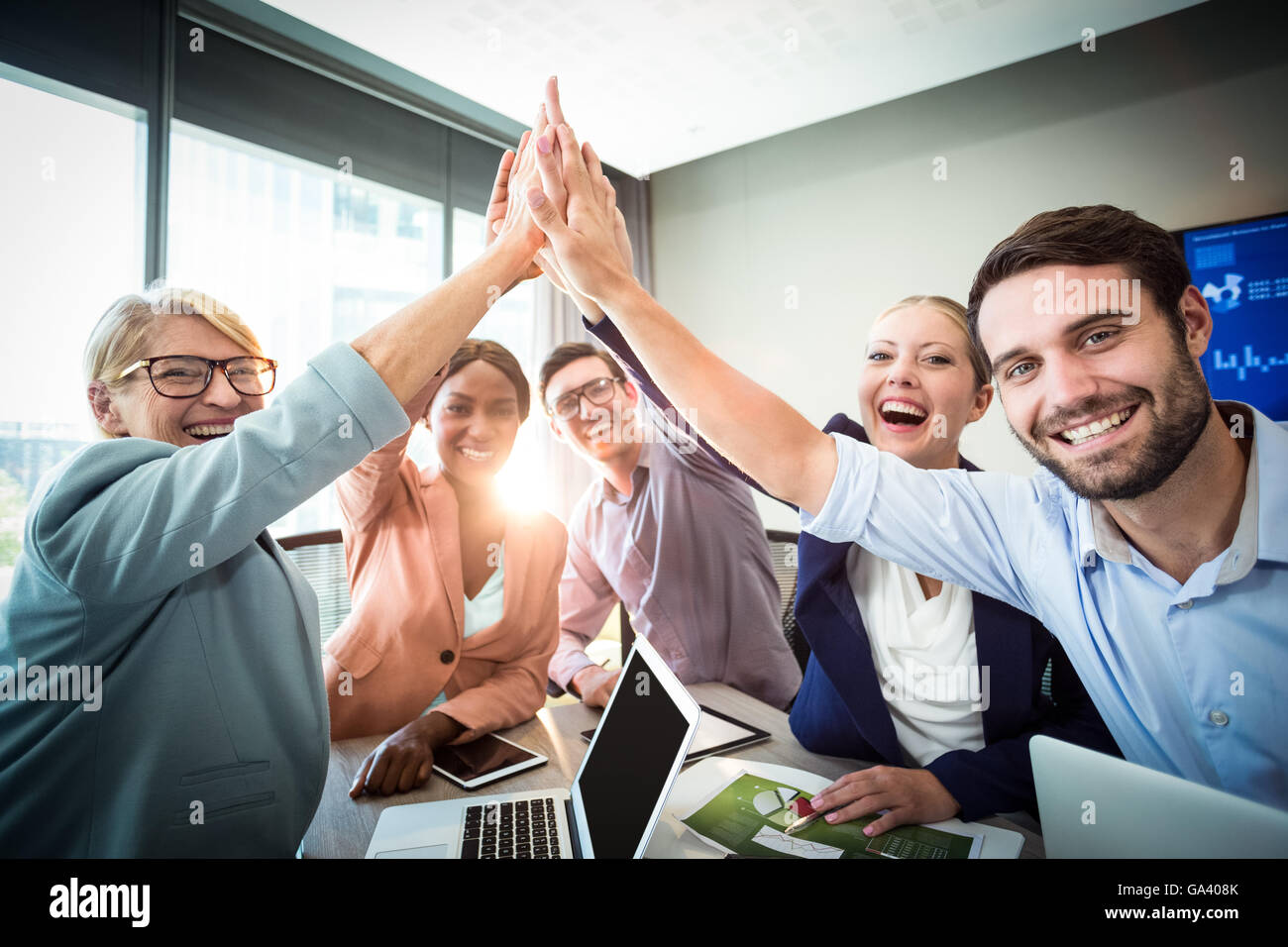 Business people giving high five at desk Stock Photo - Alamy