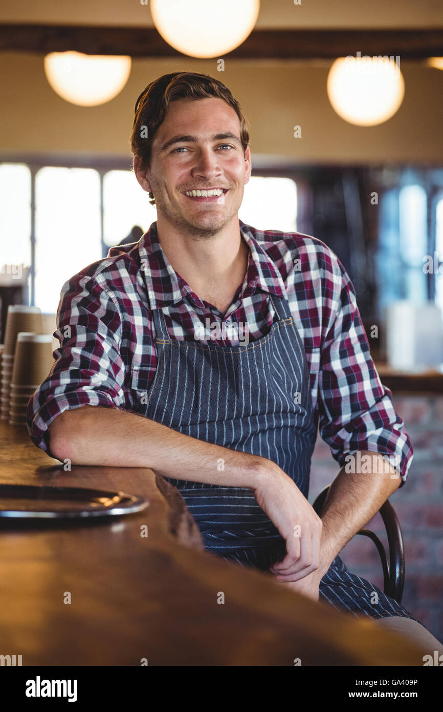Portrait of waiter sitting at bar counter Stock Photo - Alamy