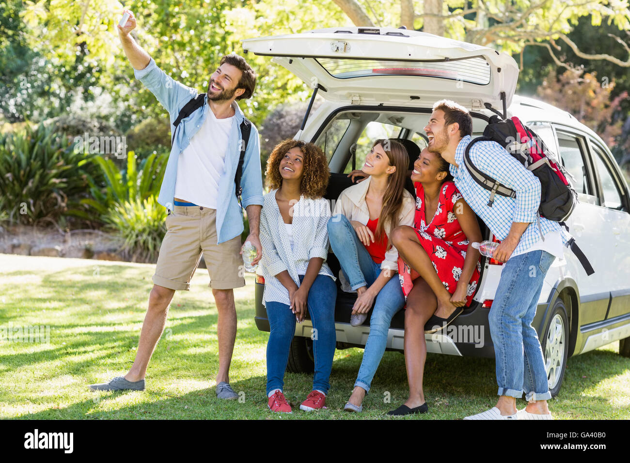 Group of friends taking a selfie from trunk of car Stock Photo - Alamy