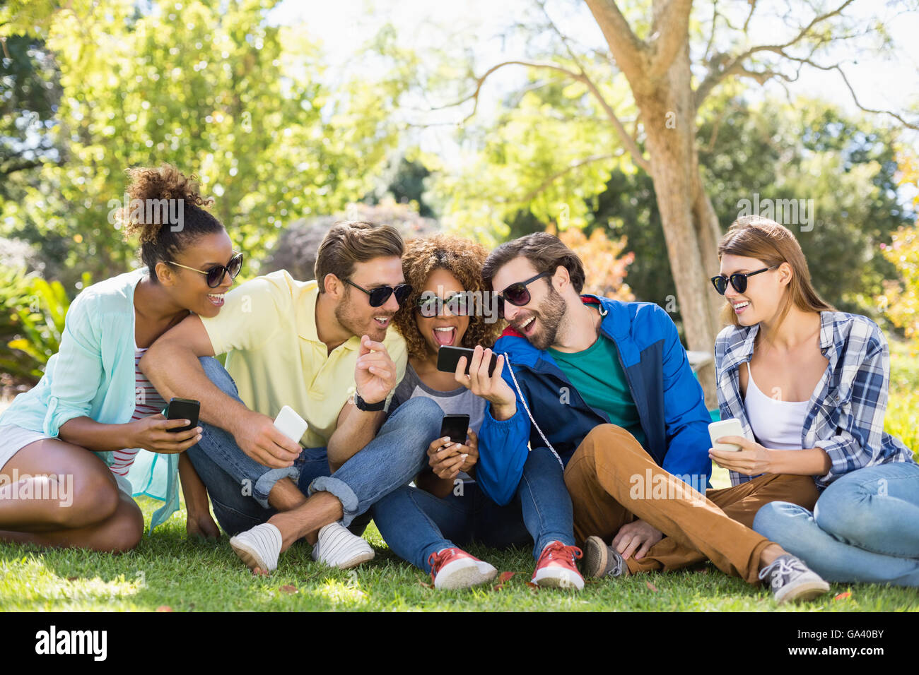 Group of friends using mobile phone Stock Photo - Alamy