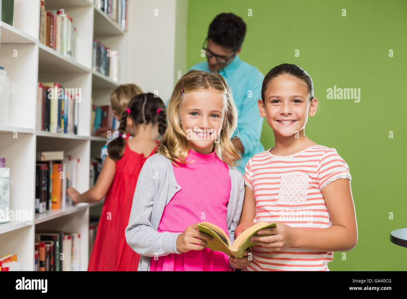Kids reading book in library Stock Photo - Alamy
