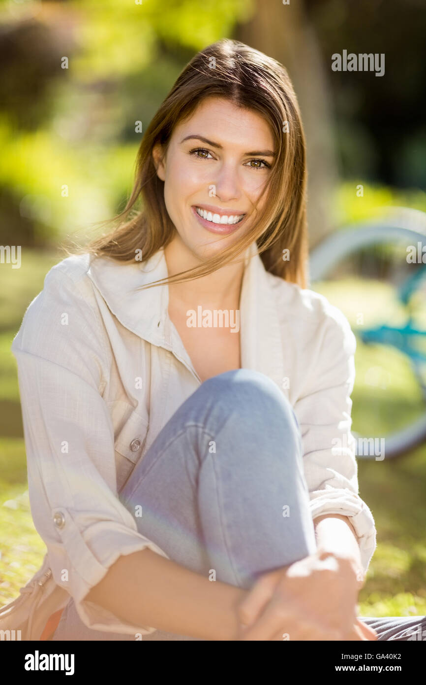 Beautiful woman sitting in park Stock Photo - Alamy