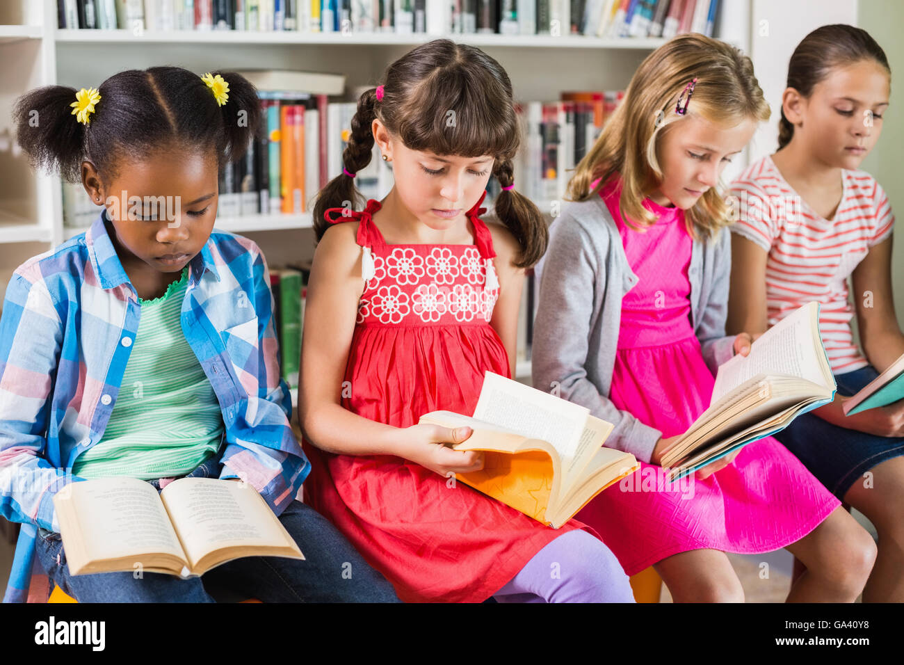 Kids reading a book in library Stock Photo - Alamy