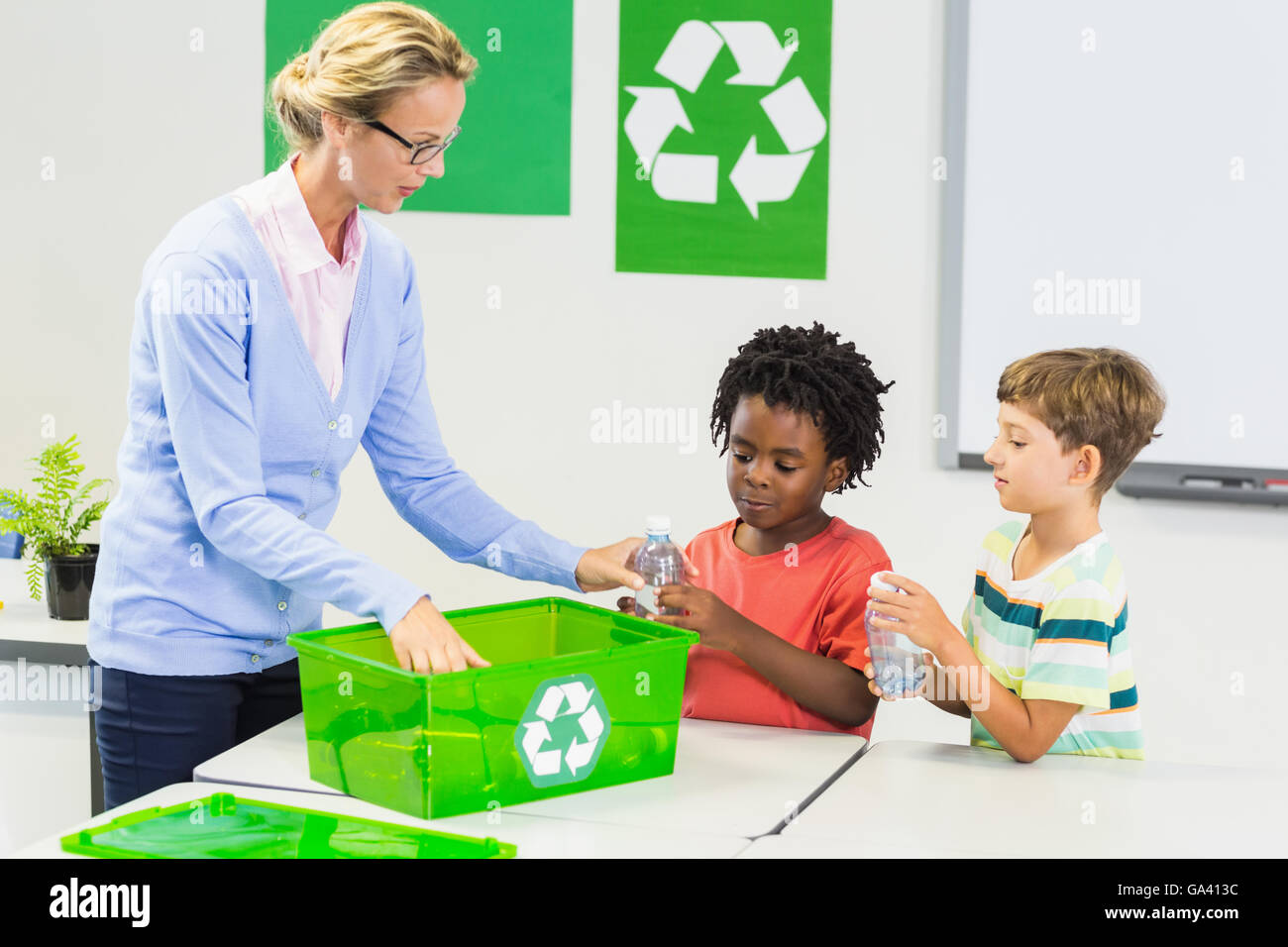 Teacher and kids discussing about recycle Stock Photo - Alamy