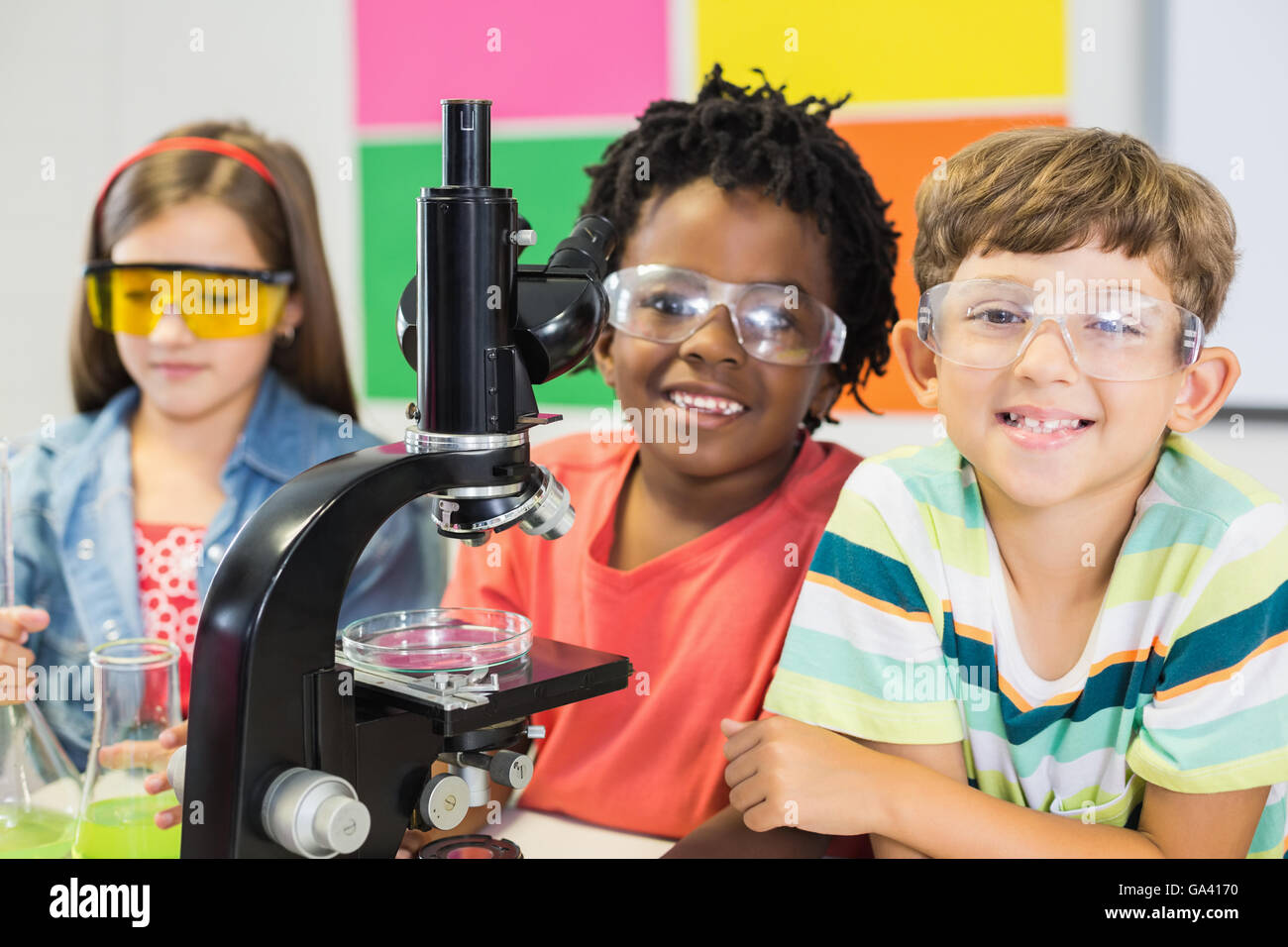 Kids doing experiment on microscope in laboratory Stock Photo - Alamy