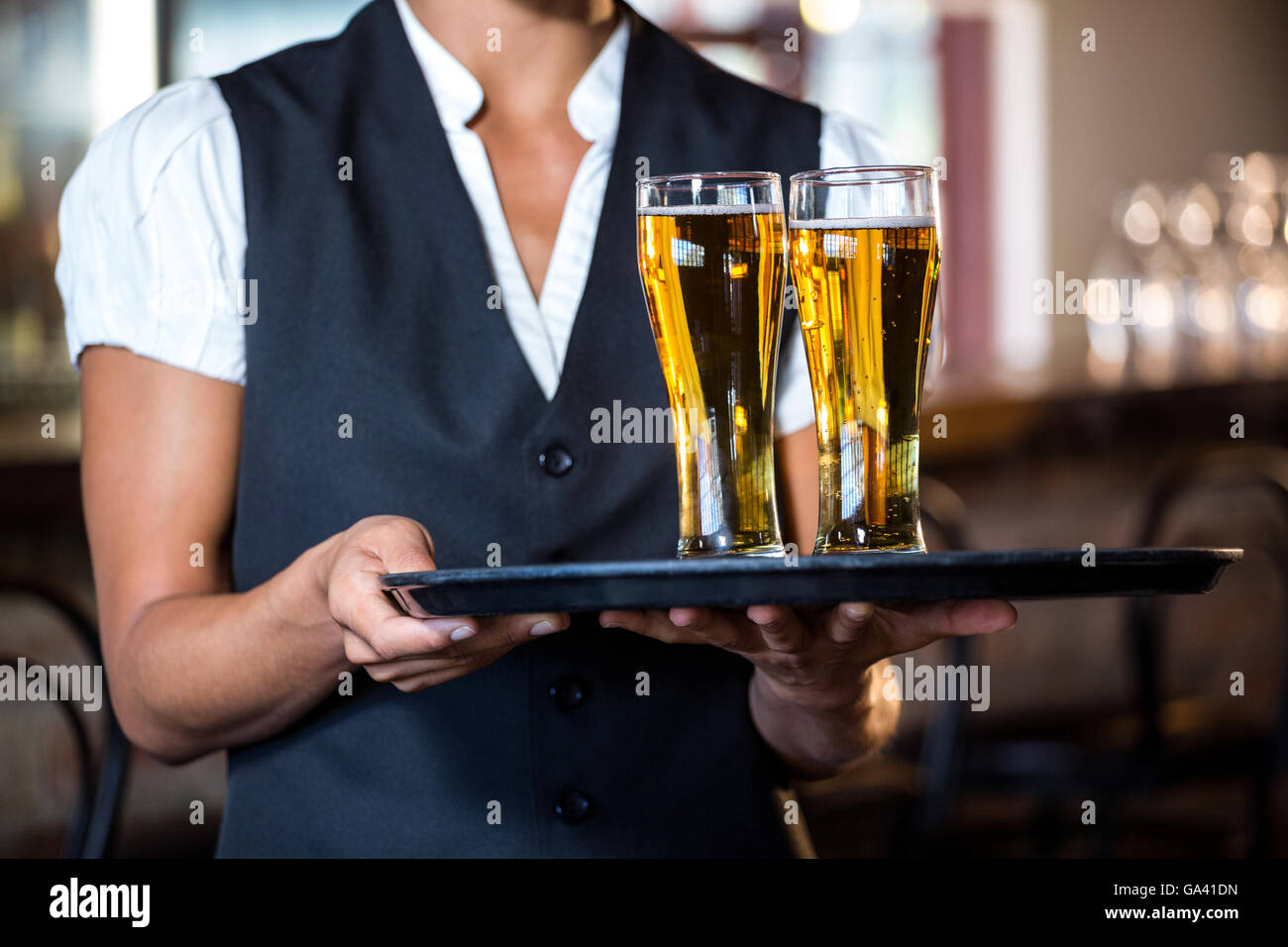 Waitress holding serving tray with two glass of beer Stock Photo - Alamy