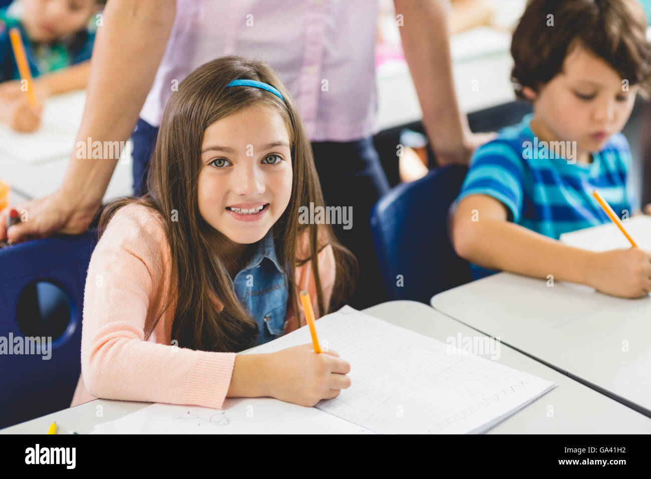 School girl doing homework in classroom Stock Photo - Alamy