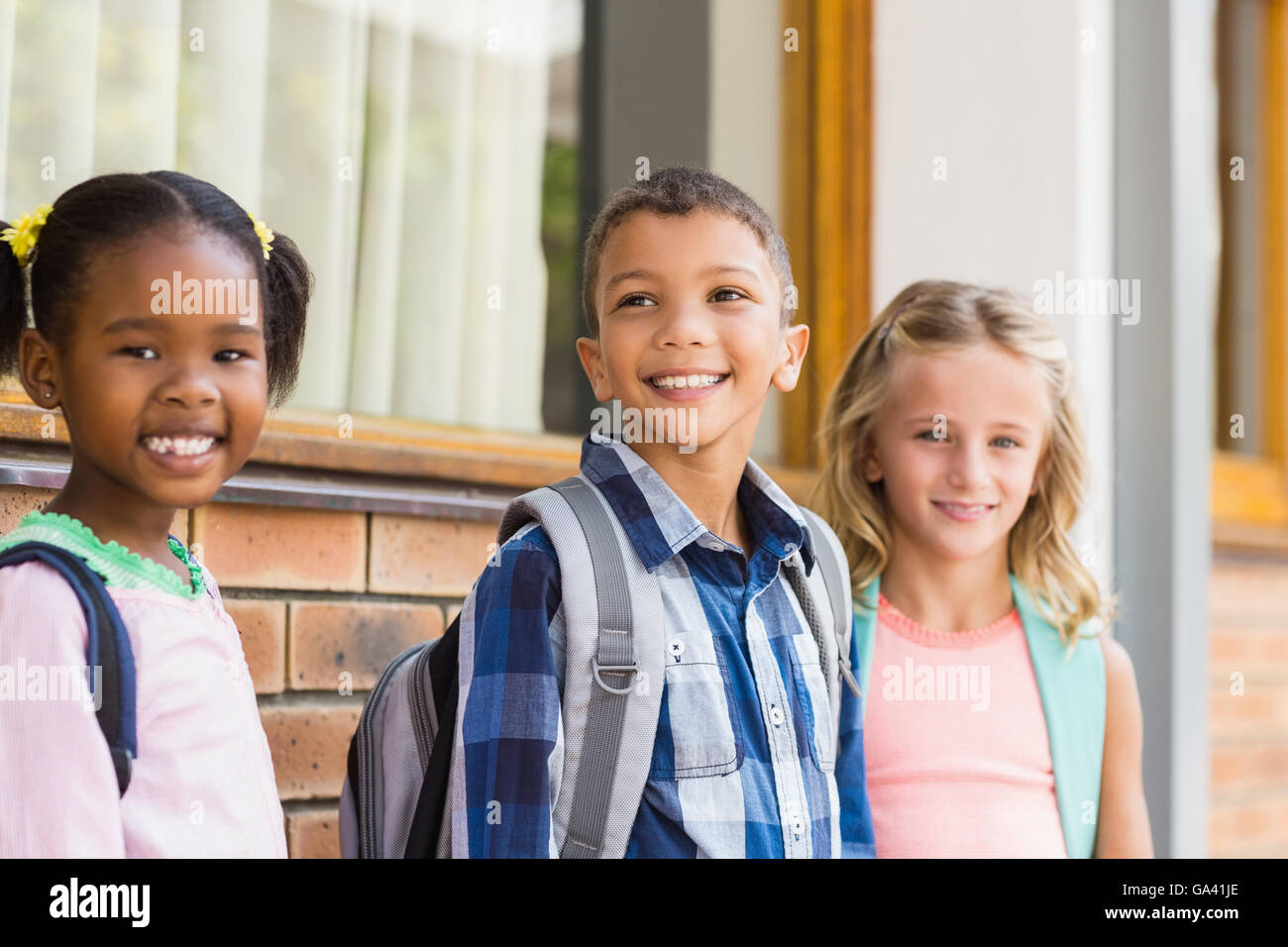 Smiling school kids standing in corridor Stock Photo - Alamy