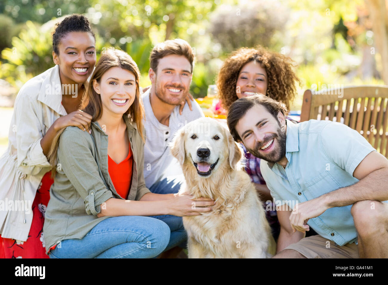 Group of happy friends sitting together with the dog Stock Photo - Alamy