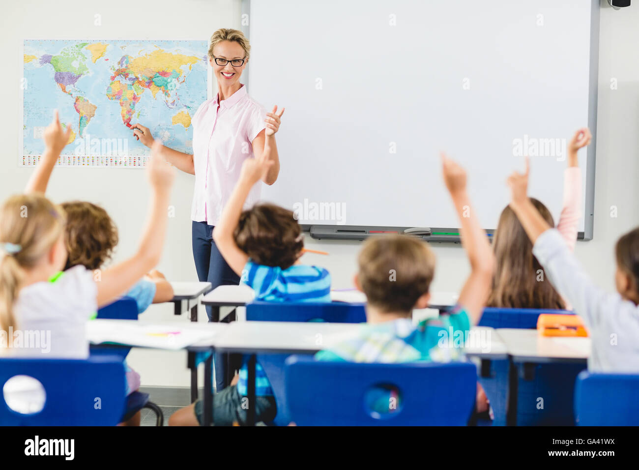 Teacher teaching kids in classroom Stock Photo - Alamy