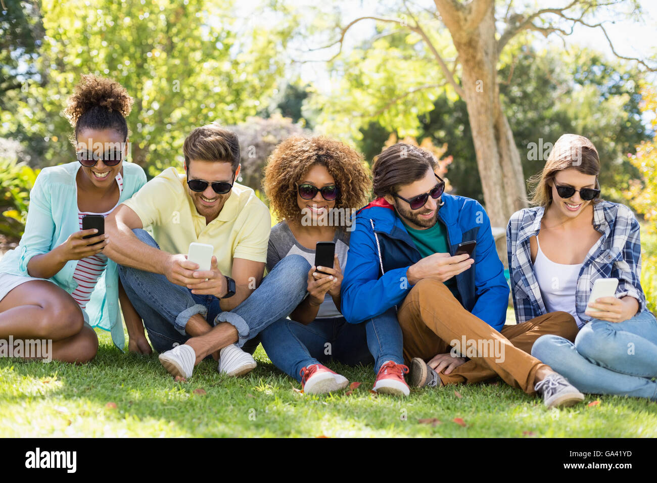 Group of friends using mobile phone Stock Photo - Alamy