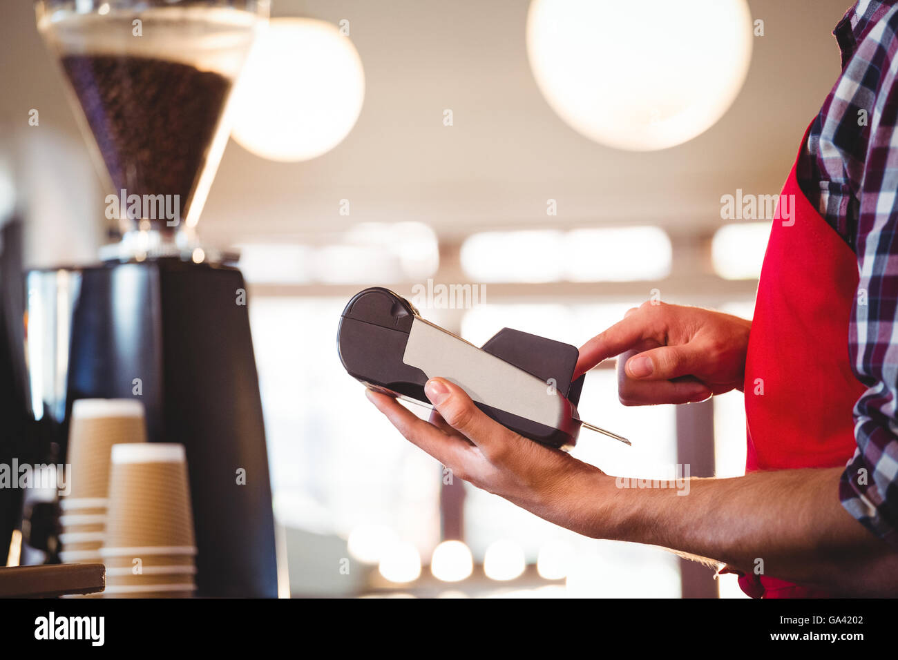 Mid section of waiter using credit card machine Stock Photo - Alamy