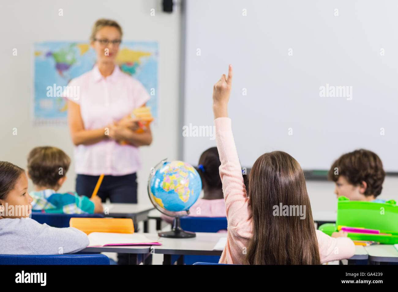 Pupil with hands up during lesson Stock Photo - Alamy