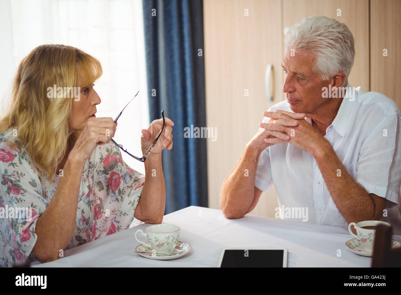 Senior couple discussing around a table Stock Photo - Alamy