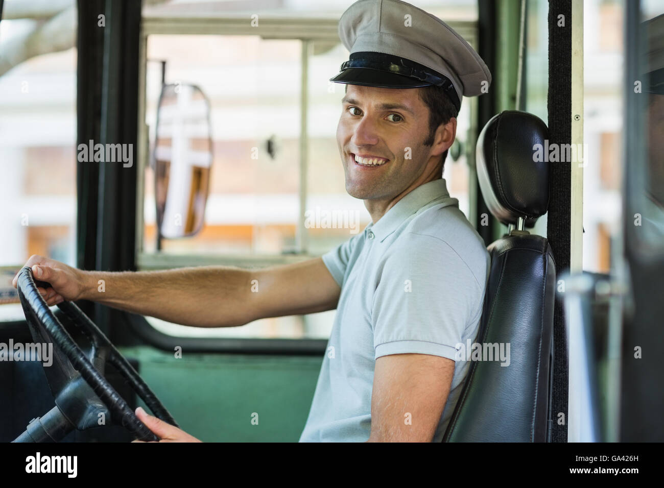 Smiling bus driver driving a bus Stock Photo - Alamy