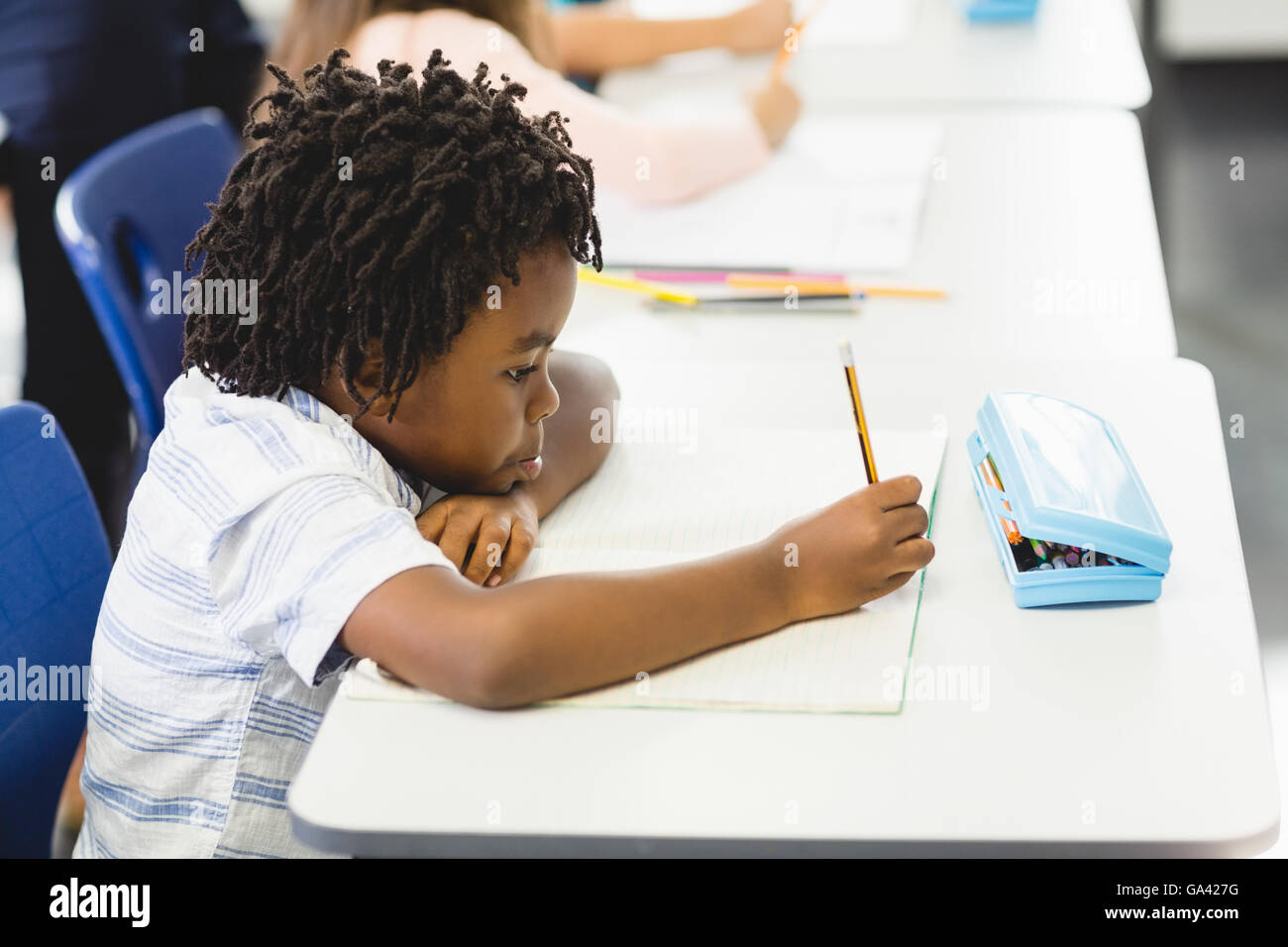 School boy doing homework in classroom Stock Photo - Alamy