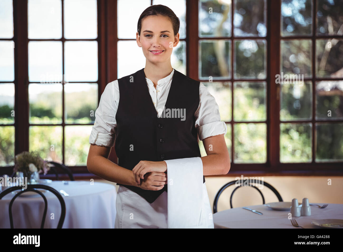 Waitress with napkin draped over her hand Stock Photo - Alamy
