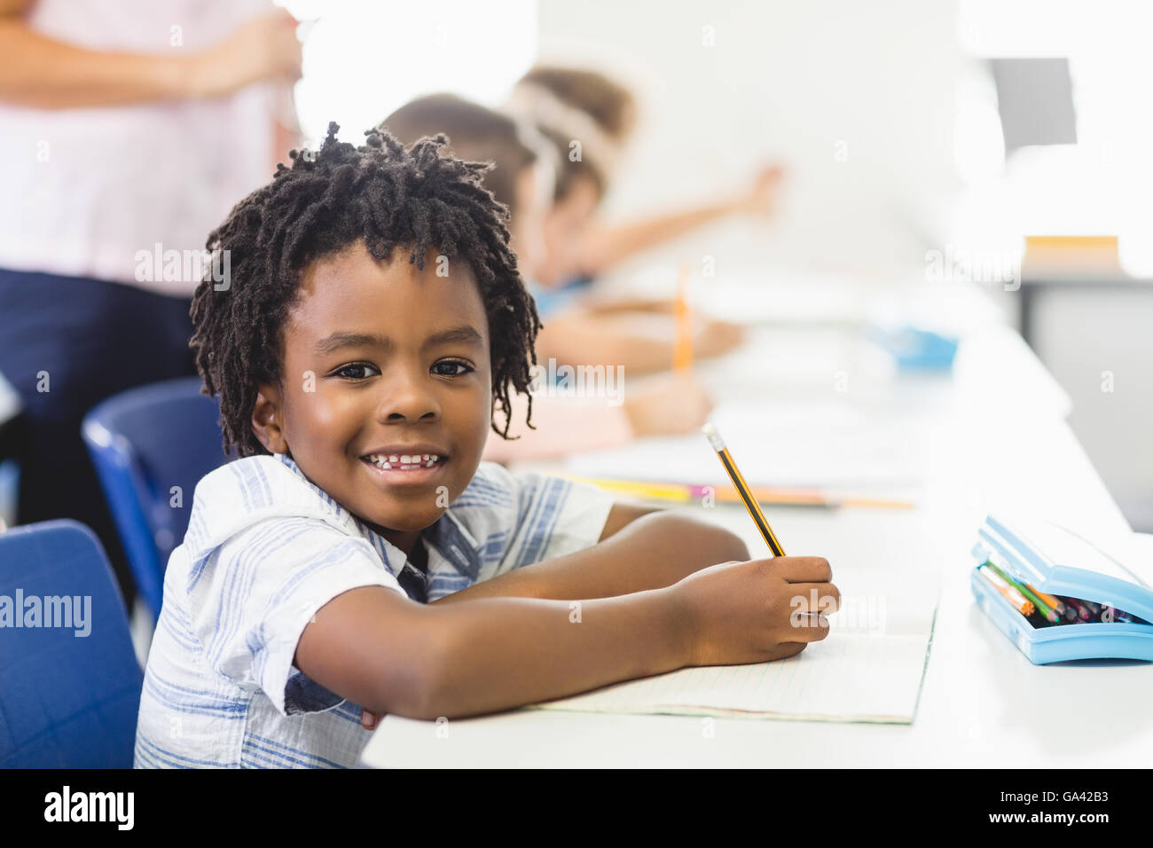 School boy doing homework in classroom Stock Photo - Alamy
